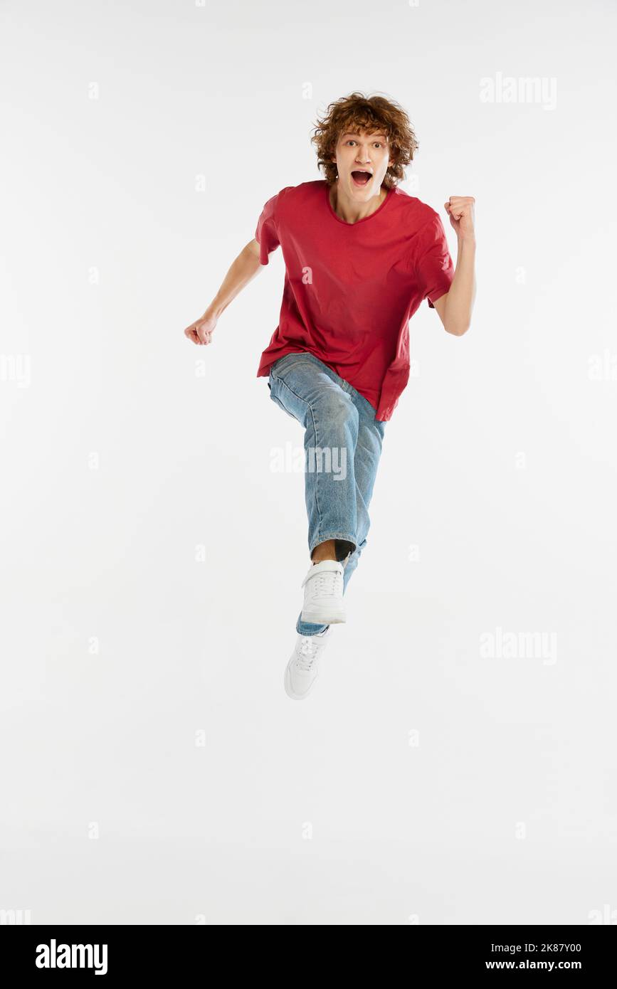 Excited young man running isolated over white background. Sport, dance ...