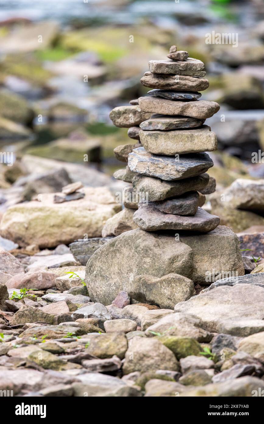 A vertical shot of balanced rough rocks on a ground Stock Photo - Alamy