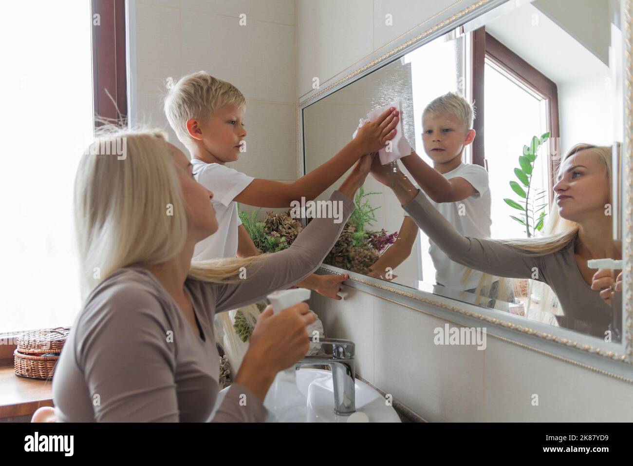 mother and son do cleaning together and clean the bathroom mirror Stock ...