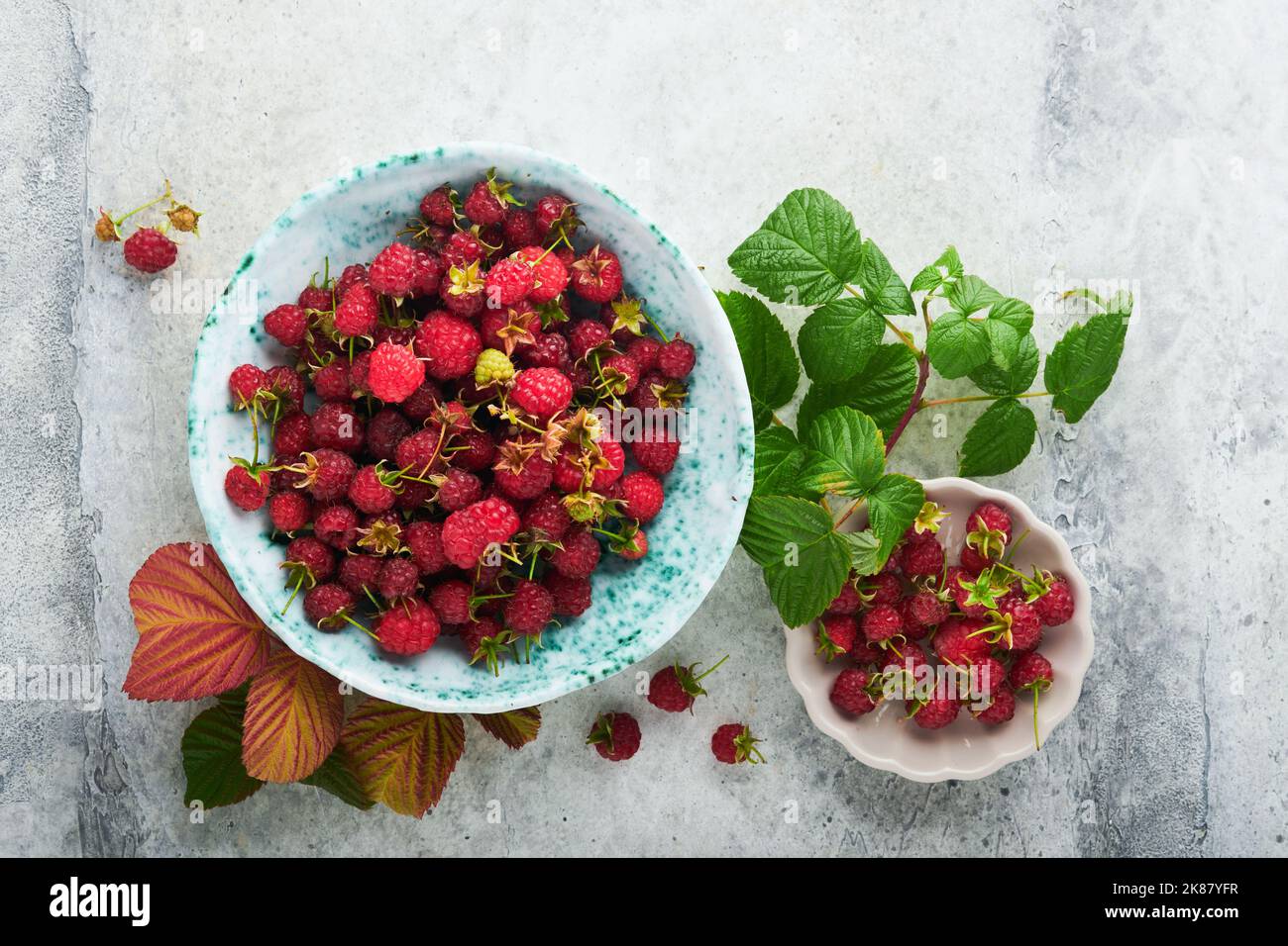 Raspberry. Branch of ripe raspberries with leaves on old concrete tile ...