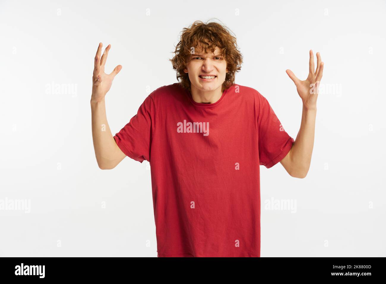 Looks annoyed. Angry young boy raising his hands up with anger isolated ...