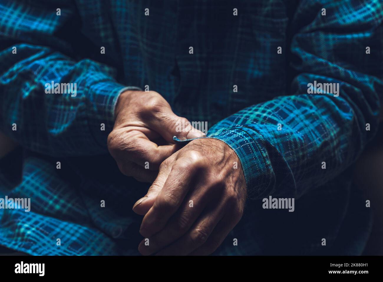 The old man fastens a button on the sleeve of his shirt Stock Photo - Alamy