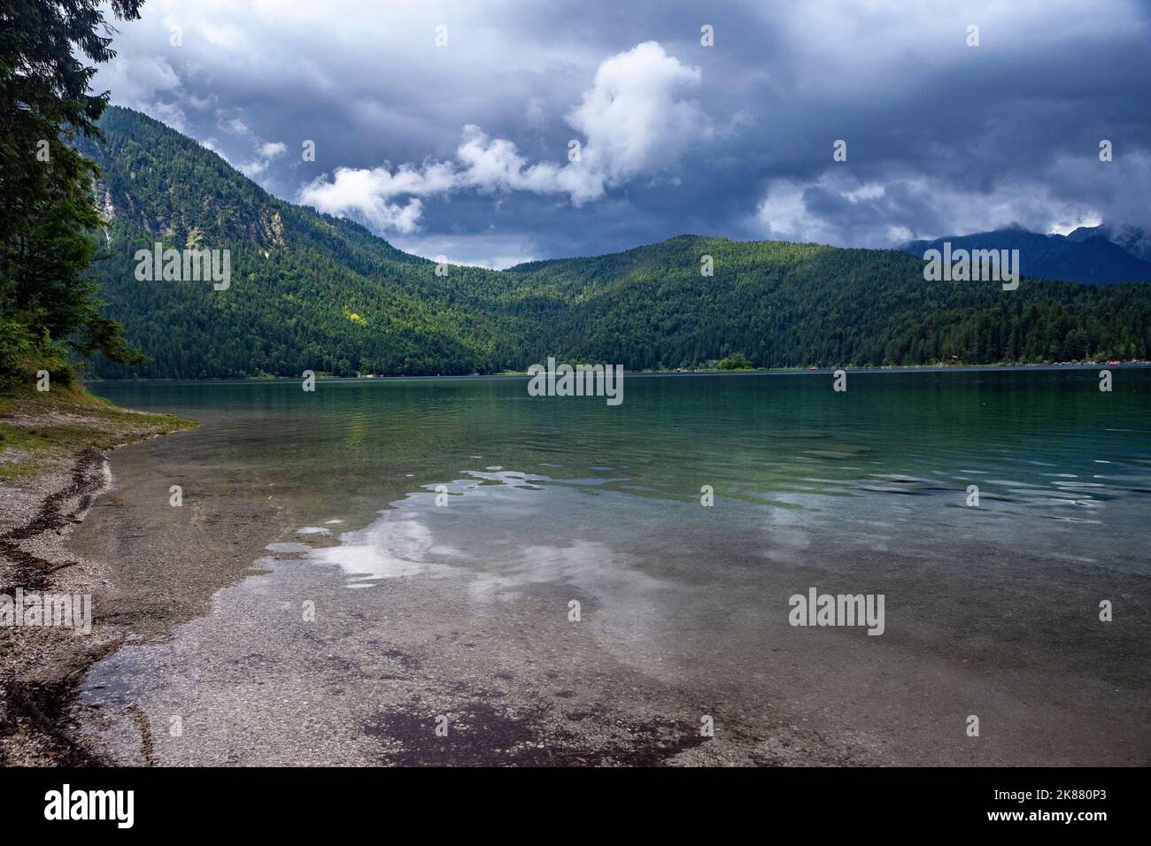 A scenic view of a lake in the green Alps under a cloudy sky Stock ...