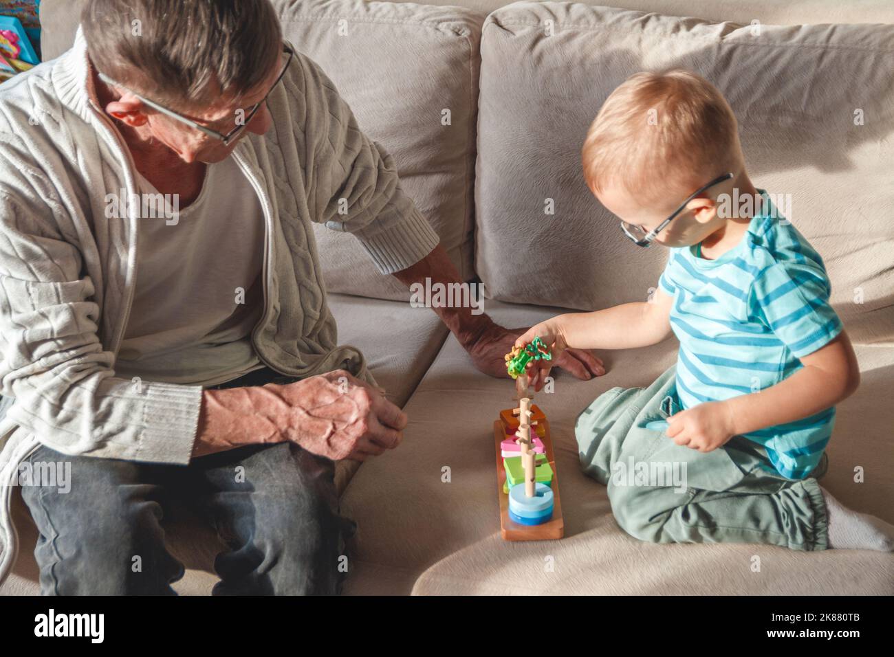 Elderly grandpa or grandfather plays with his little grandson Stock ...