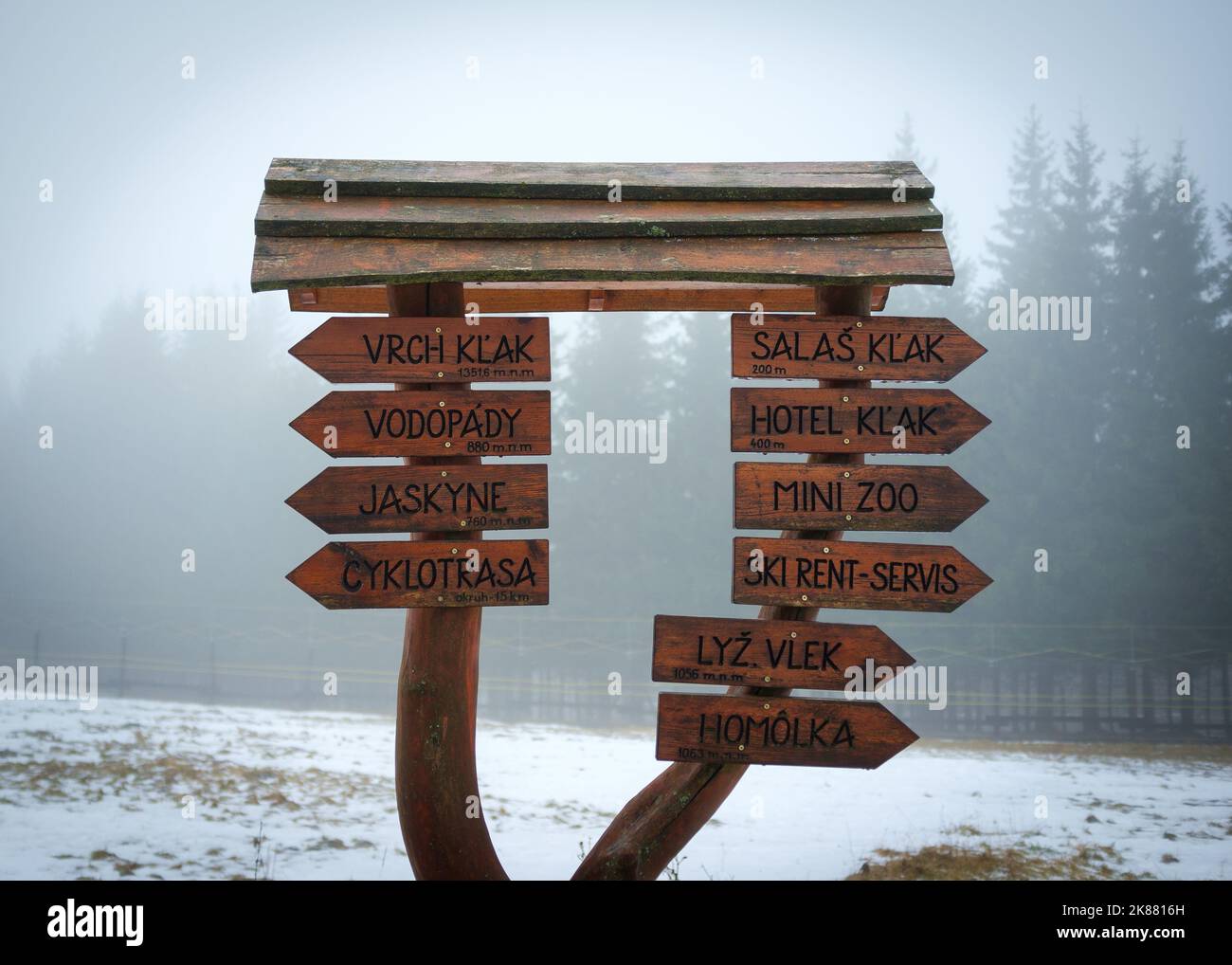 The wooden hiking signs in Fackov village with a dense forest covered ...