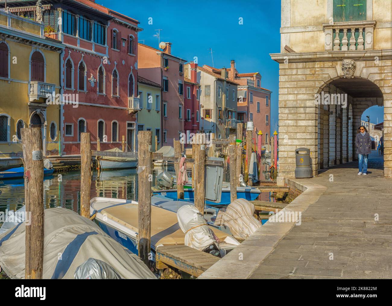Chioggia cityscape with narrow water canal with moored boats, buildings ...