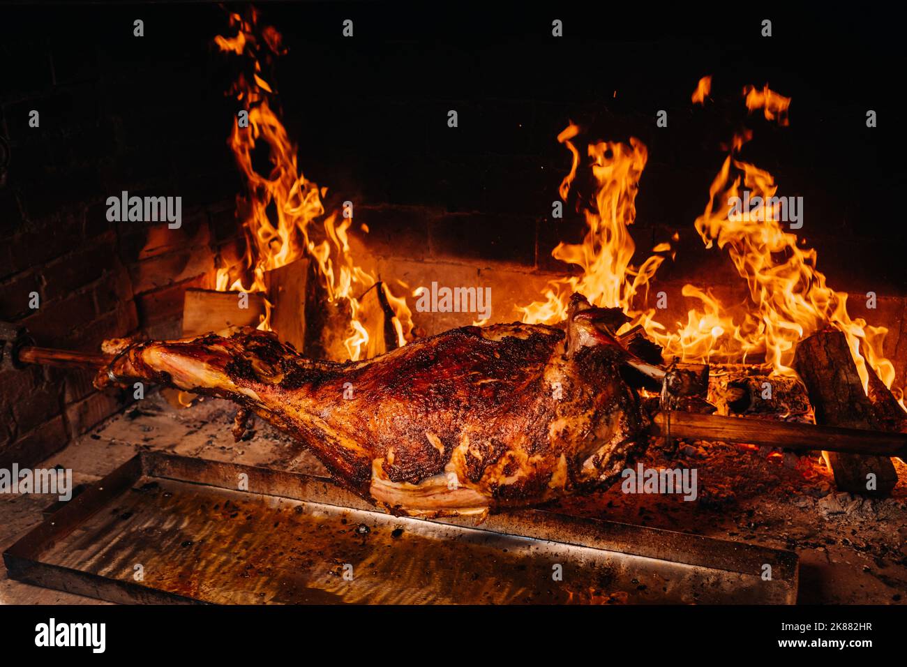 The lamb is cooked entirely on a spit on the fire. Cooking Stock Photo ...