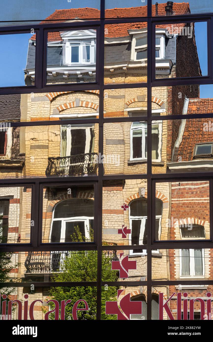 Reflection of houses lit by the sun in a facade made of glazed panels ...