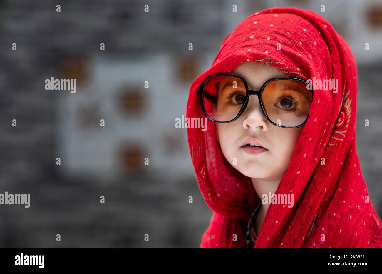 A closeup portrait of a Southeast Asian girl with red dupatta and ...