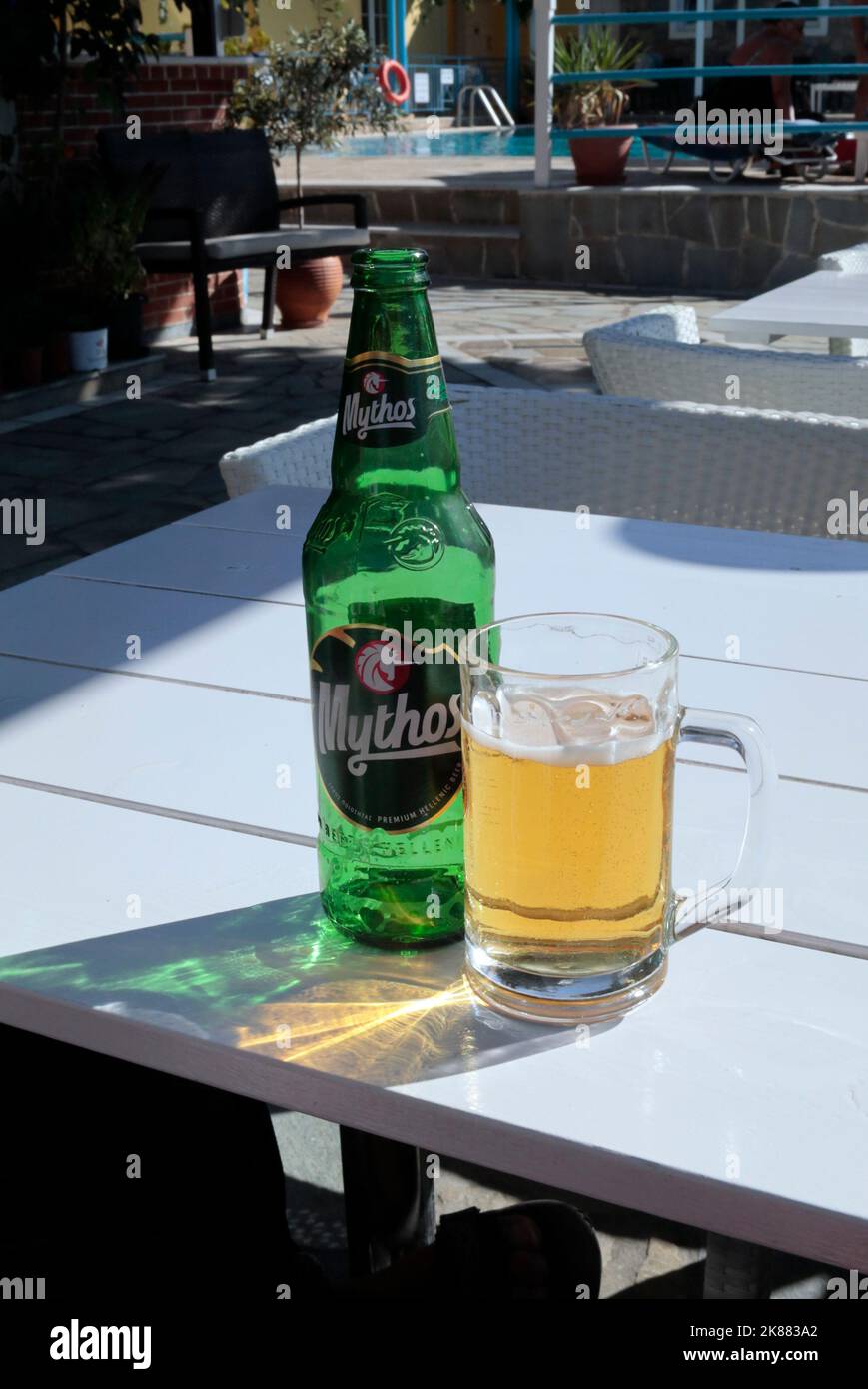 Single Green Mythos Greek beer bottle - and glass of Mythos partially ...