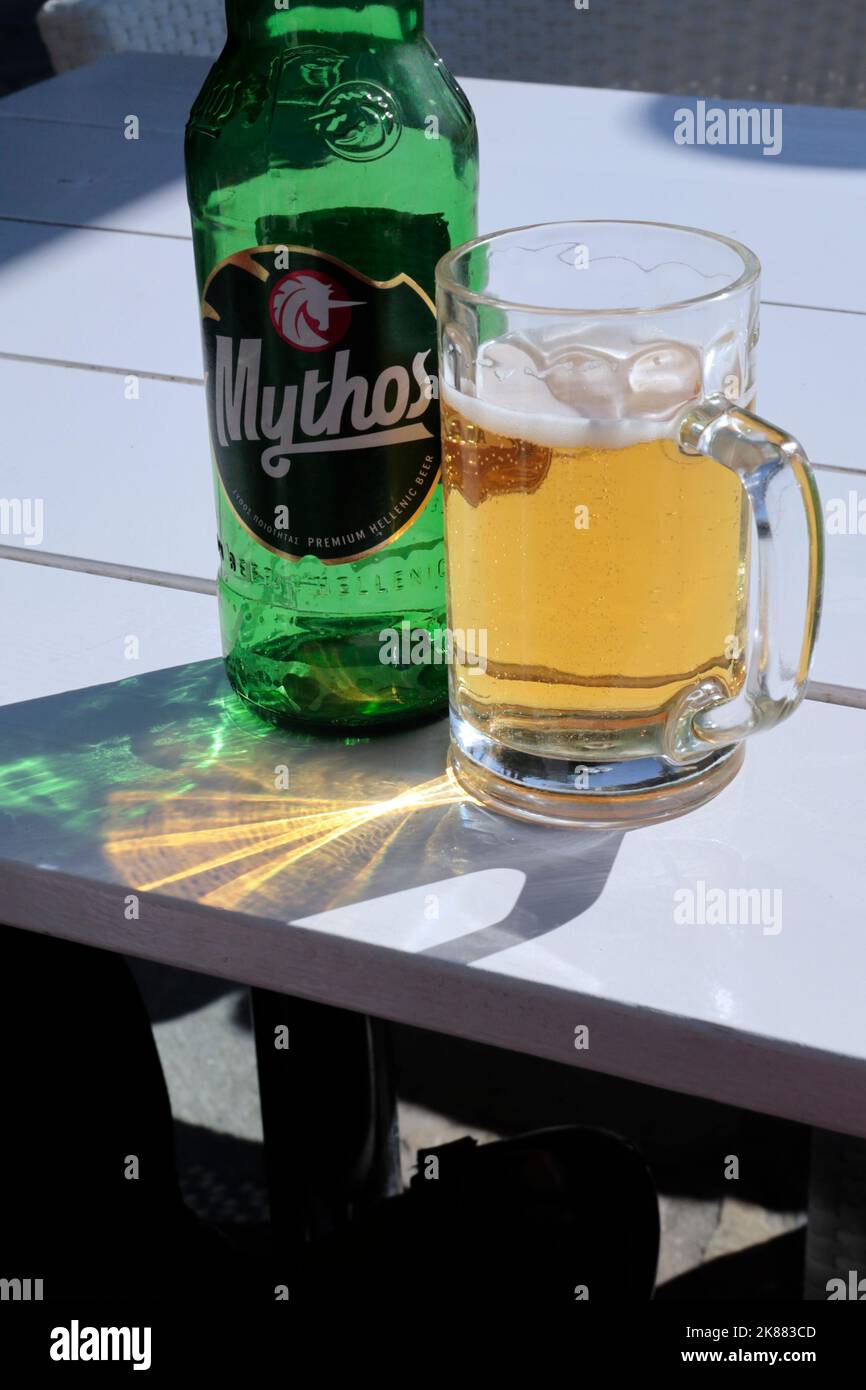 Single Green Mythos Greek beer bottle - and glass of Mythos partially ...