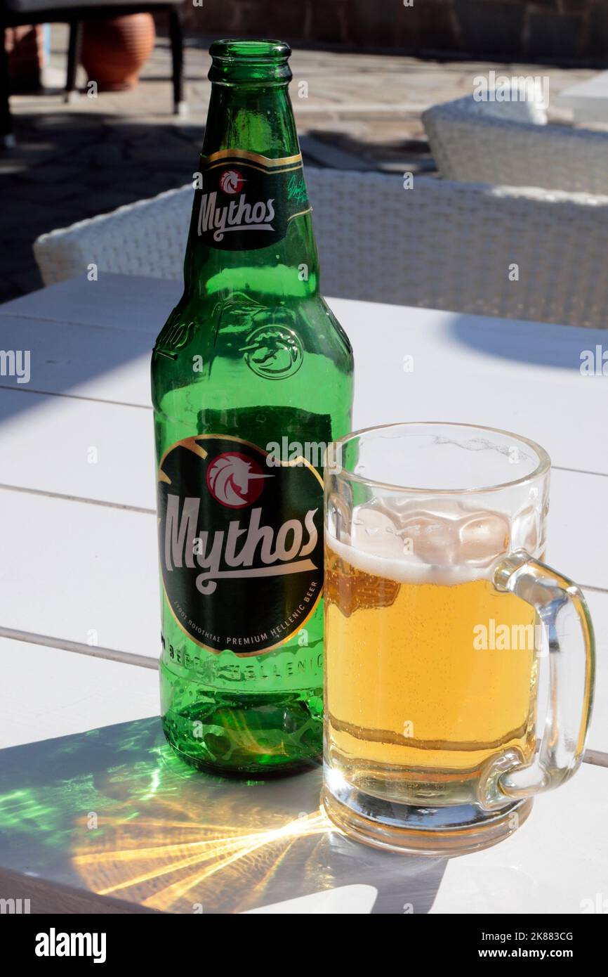 Single Green Mythos Greek beer bottle - and glass of Mythos partially ...