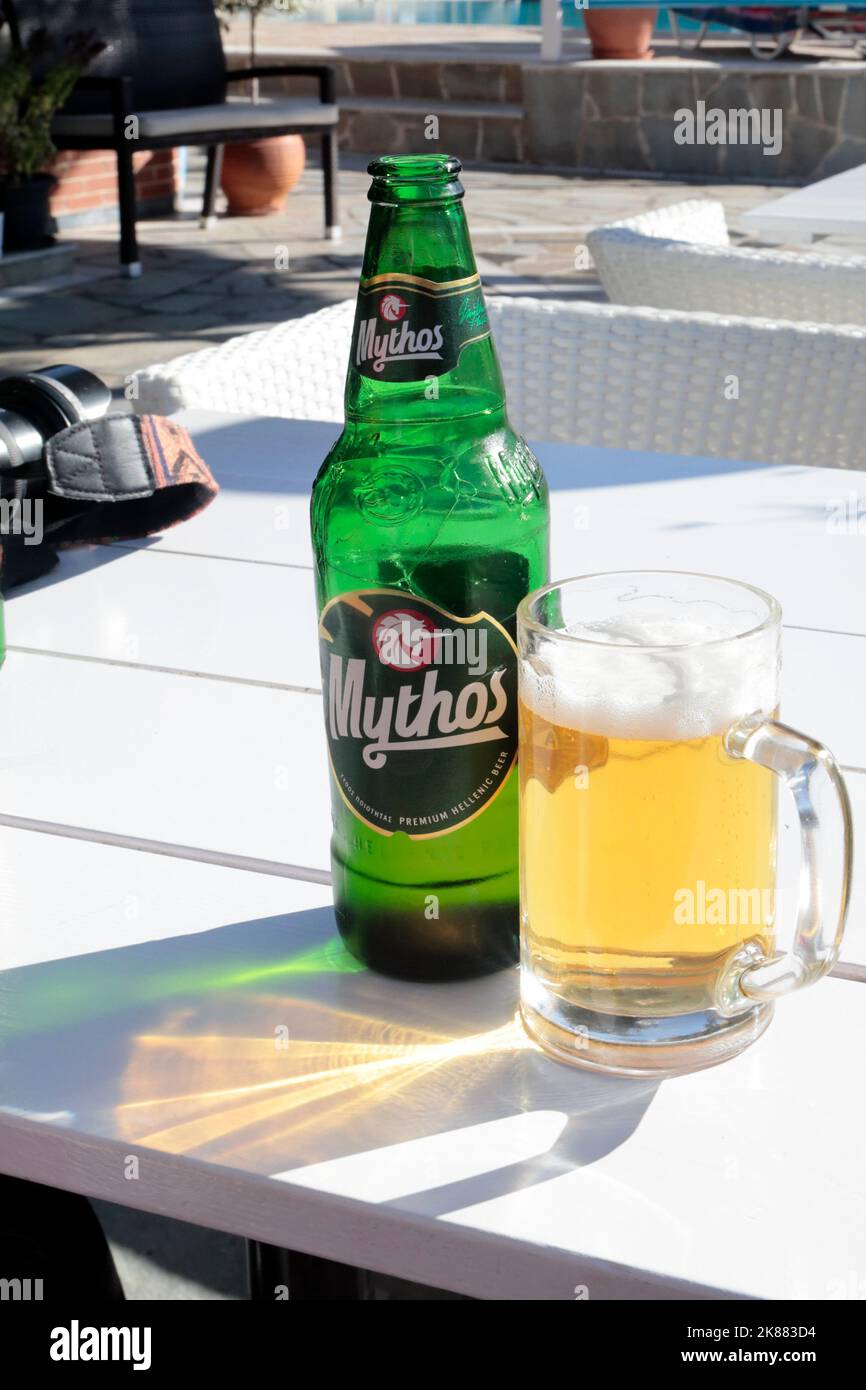 Single Green Mythos Greek beer bottle - and glass of Mythos partially ...