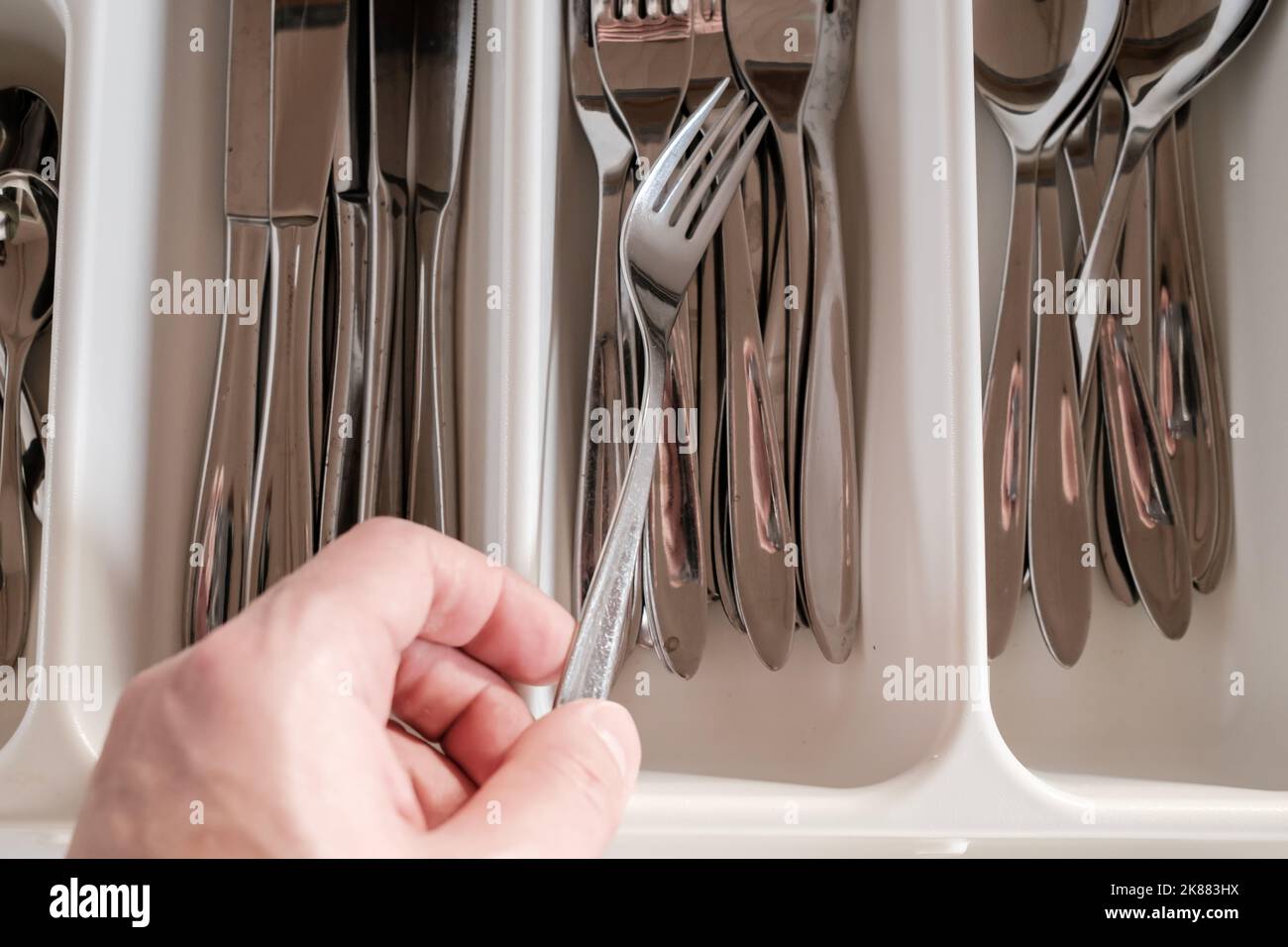 Male hand takes a fork from a drawer with cutlery. Close-up Stock Photo ...