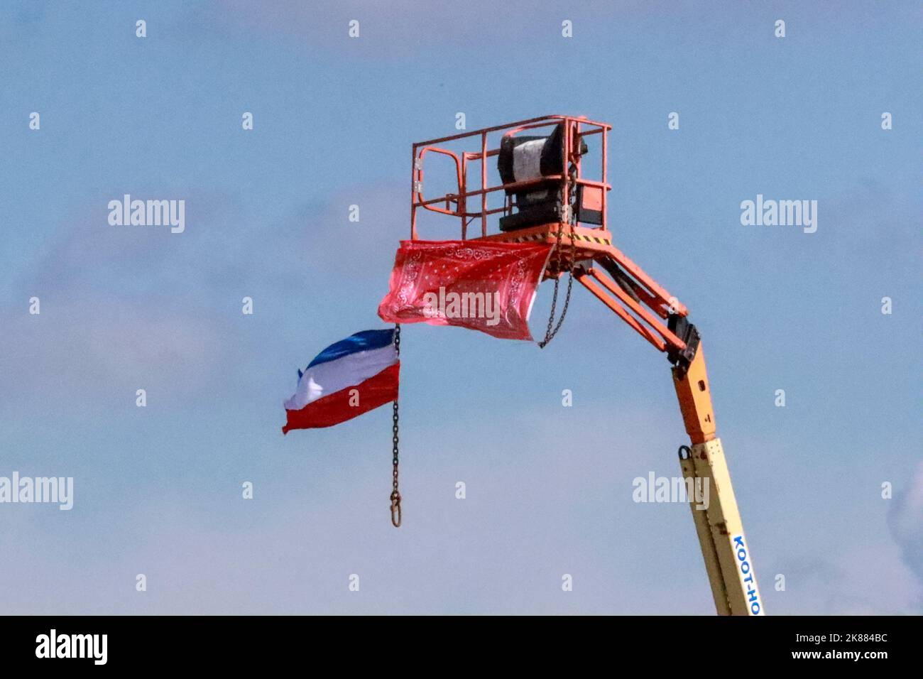 Large farmer's handkerchief and inverted flag on a cherry picker as a ...