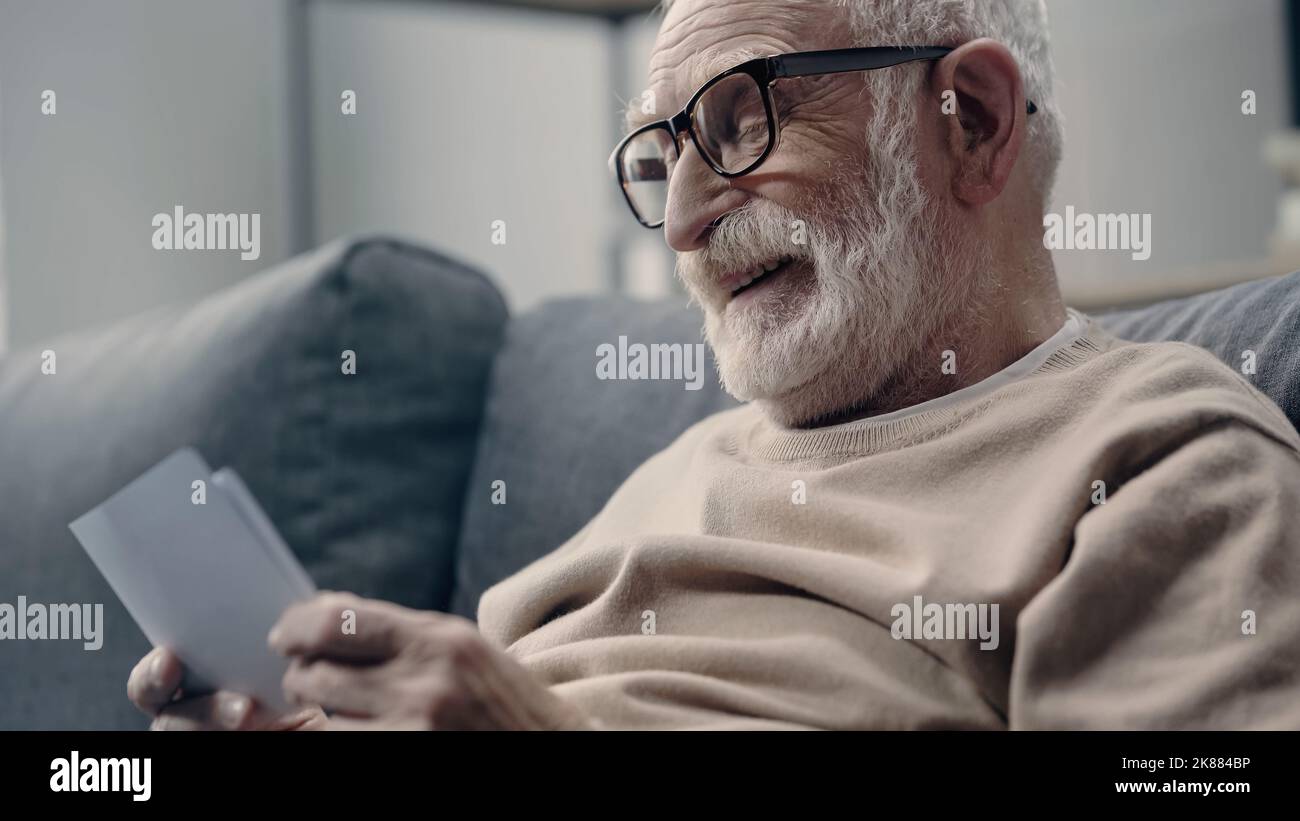 happy senior man with dementia looking at photos at home Stock Photo ...