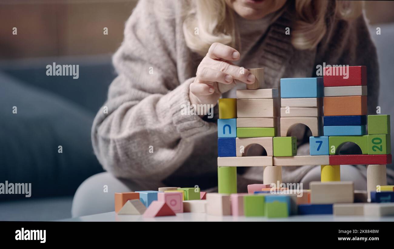 cropped view of senior woman with dementia playing with colorful ...