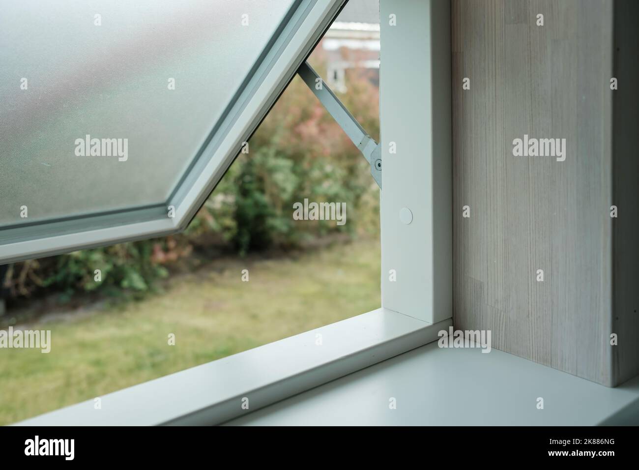 Window with condensation on the glass is open to ventilate the room ...