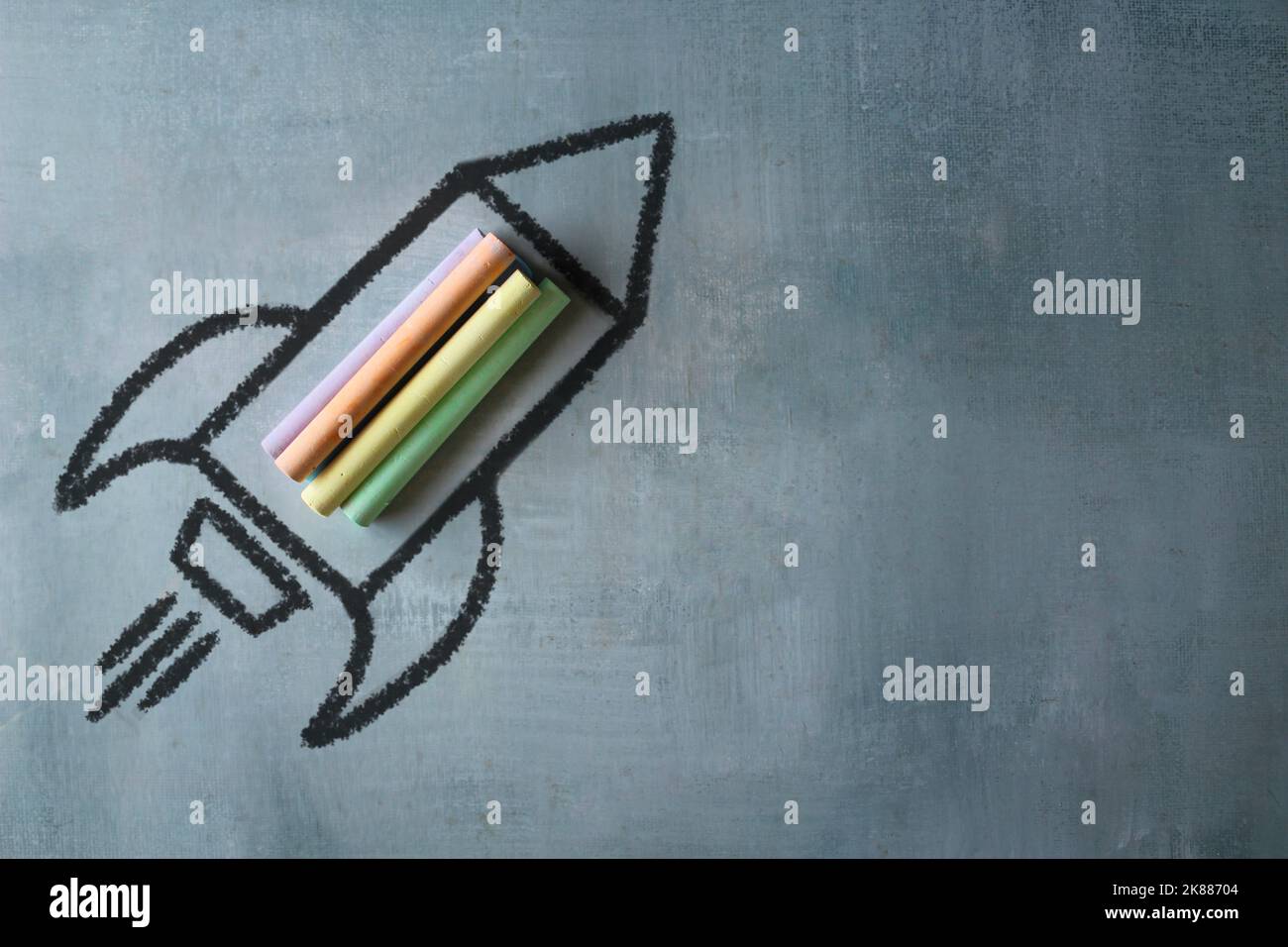 Sketch of rocket ship launch made with colorful chalk on chalkboard ...
