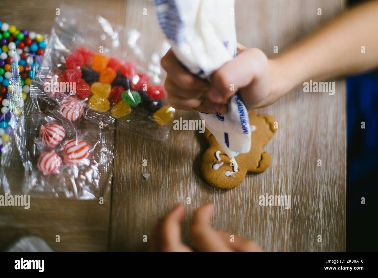 Child decorates gingerbread man with frosting and candy Stock Photo - Alamy