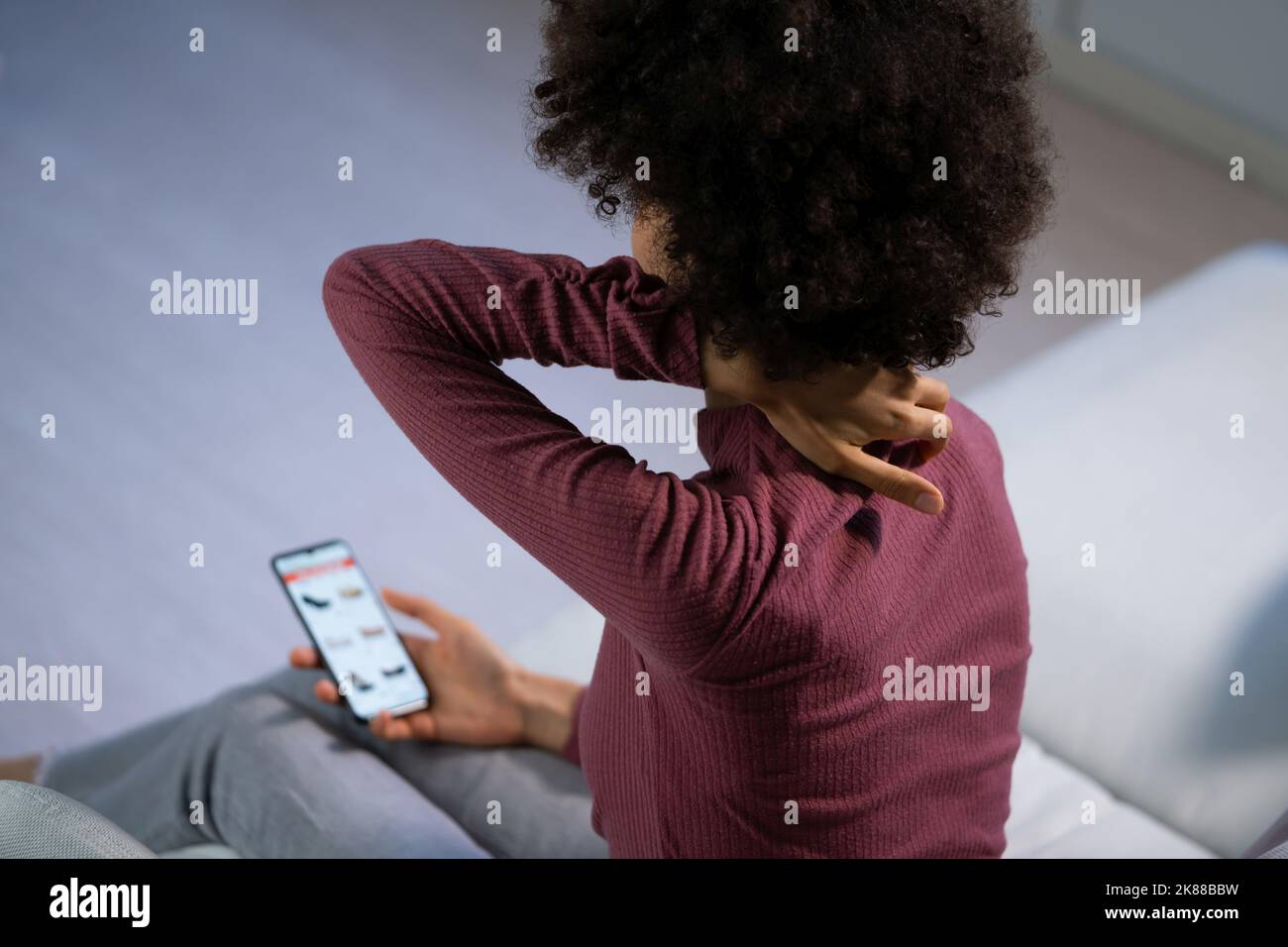 Woman With Neck Pain Sitting Using Mobile Phone Stock Photo - Alamy