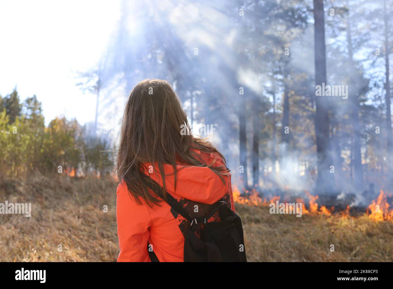 A teenage girl looks at a fire in a city park Stock Photo - Alamy