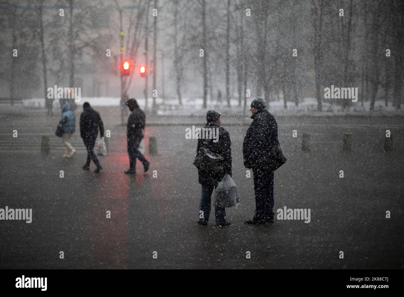 Snow outside. Snowfall in city. People in wet weather. Snowflakes fly ...