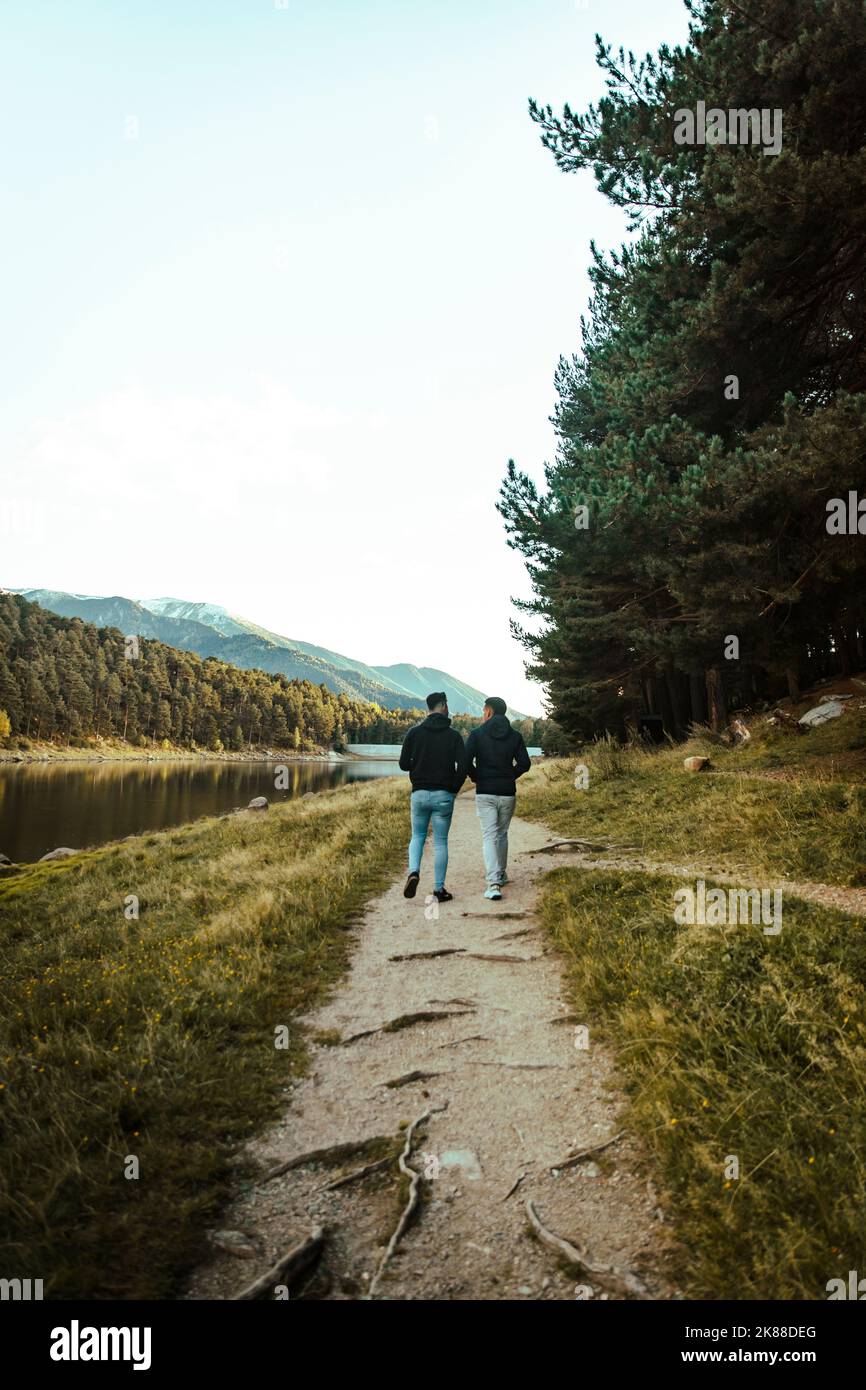 Friends walking by a lake while talking quietly Stock Photo - Alamy