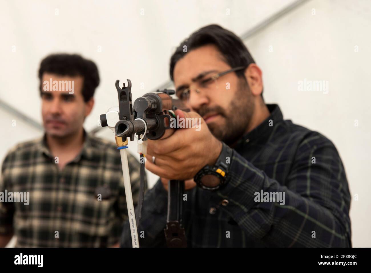 A man practice shooting with shooting simulators made in Iran at a ...