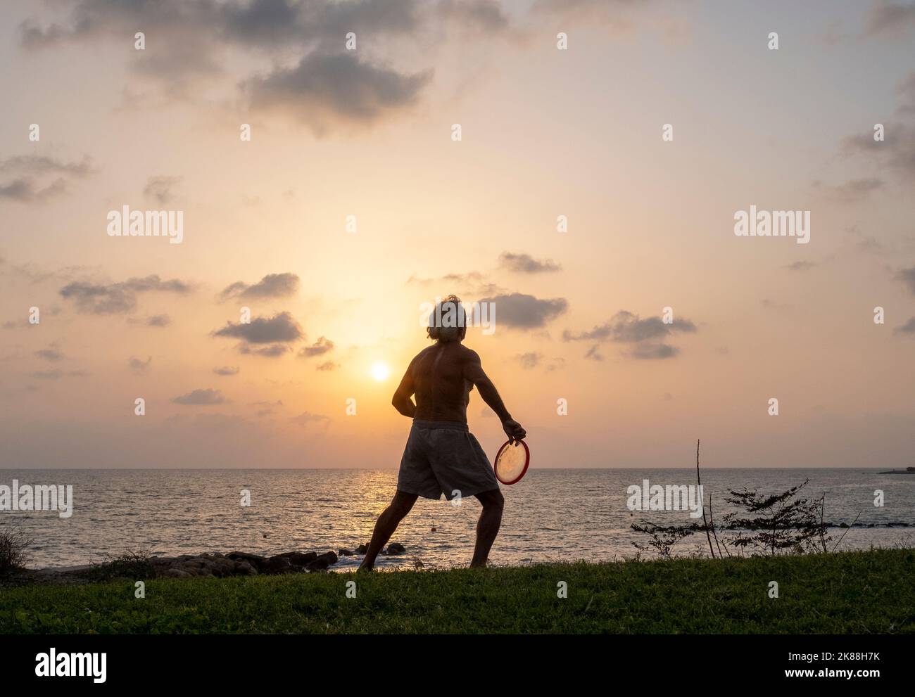 A man exercising on a beach throwing a frisbee, Paphos, Cyprus Stock ...