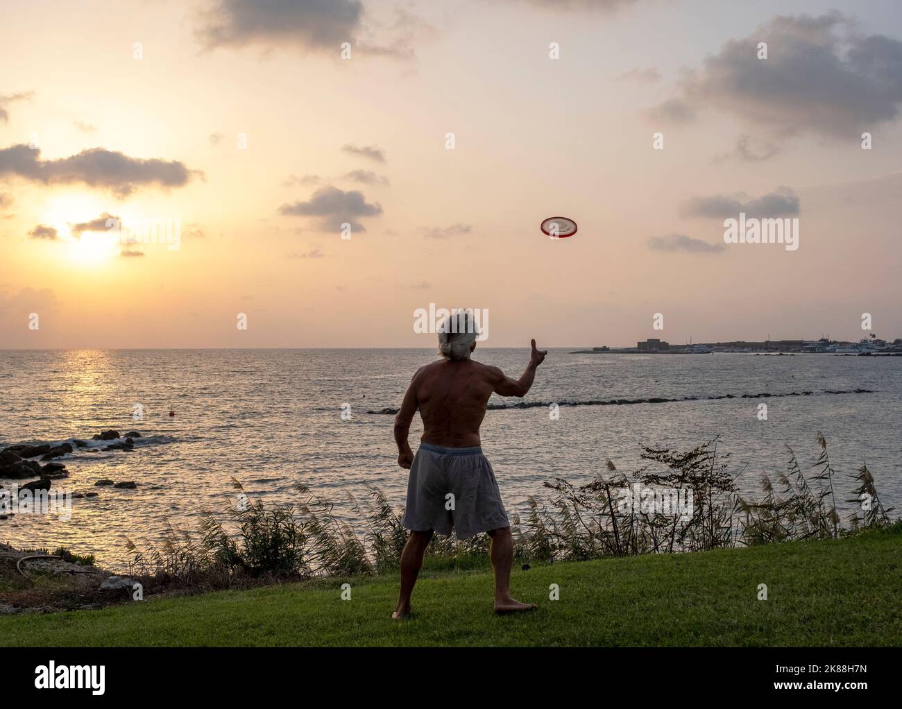 A man exercising on a beach throwing a frisbee, Paphos, Cyprus Stock ...