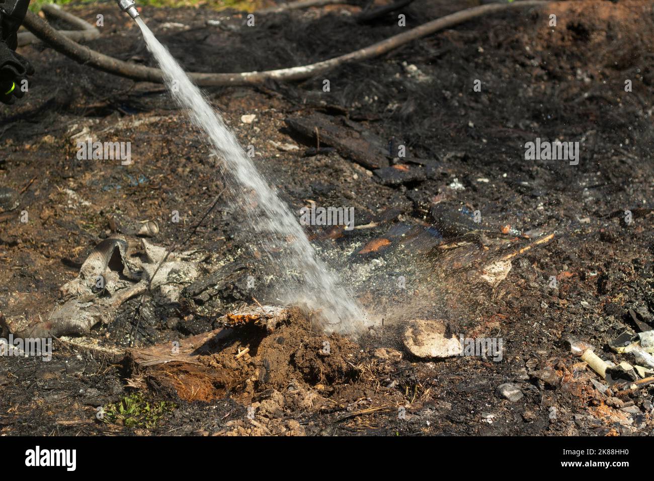 Firefighter pours water from hose. Extinguishing fire in detail. Water ...