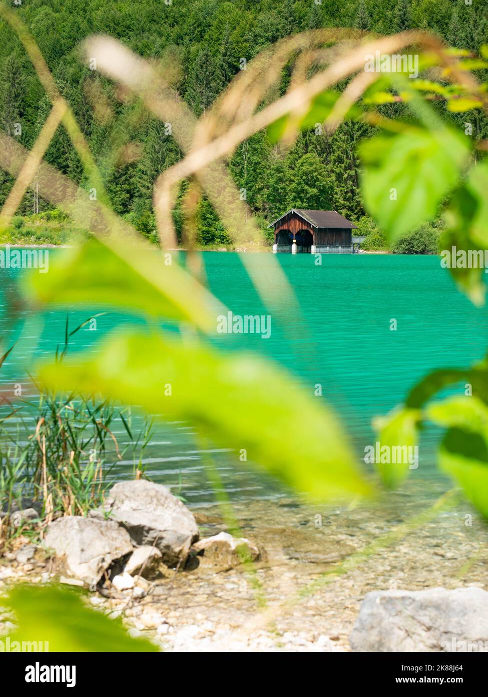 Fisher boat house and wooden hut with pier in the shore of Walchensee ...