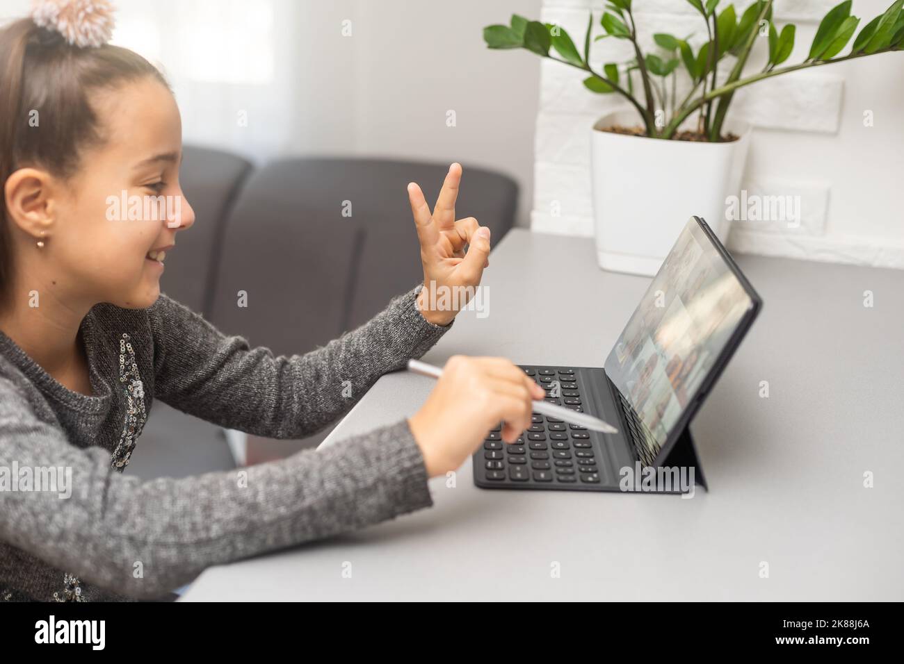 school kid girl student using digital tablet looking at screen at desk ...