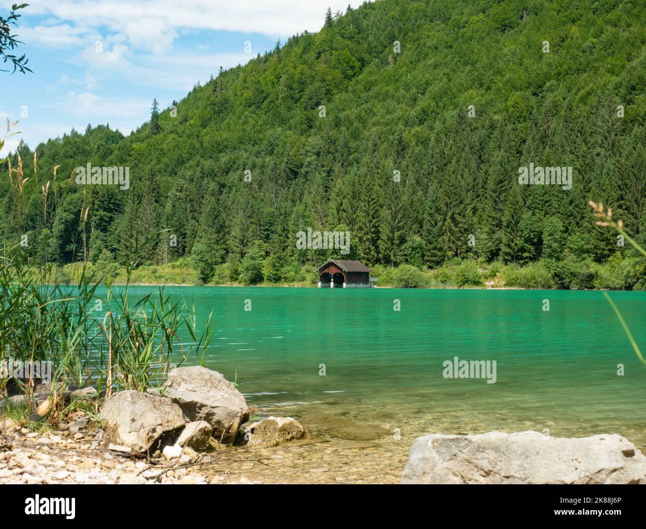 Fisher boat house and wooden hut with pier in the shore of Walchensee ...