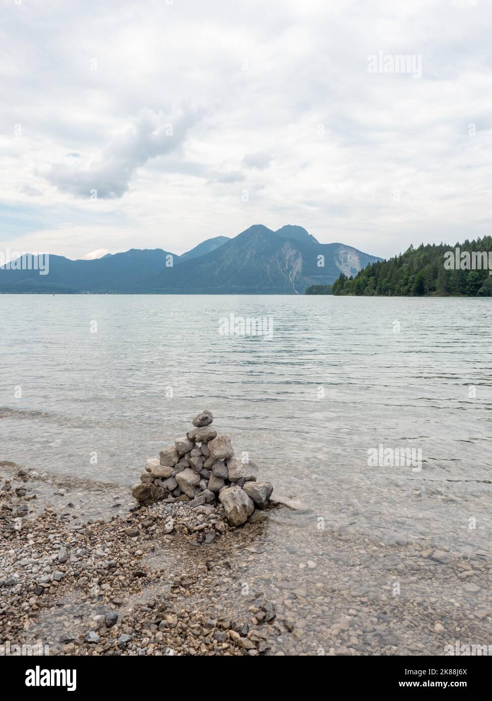 Stacked pebbles on the lake shore. Balanced stones stack. Near Alps ...