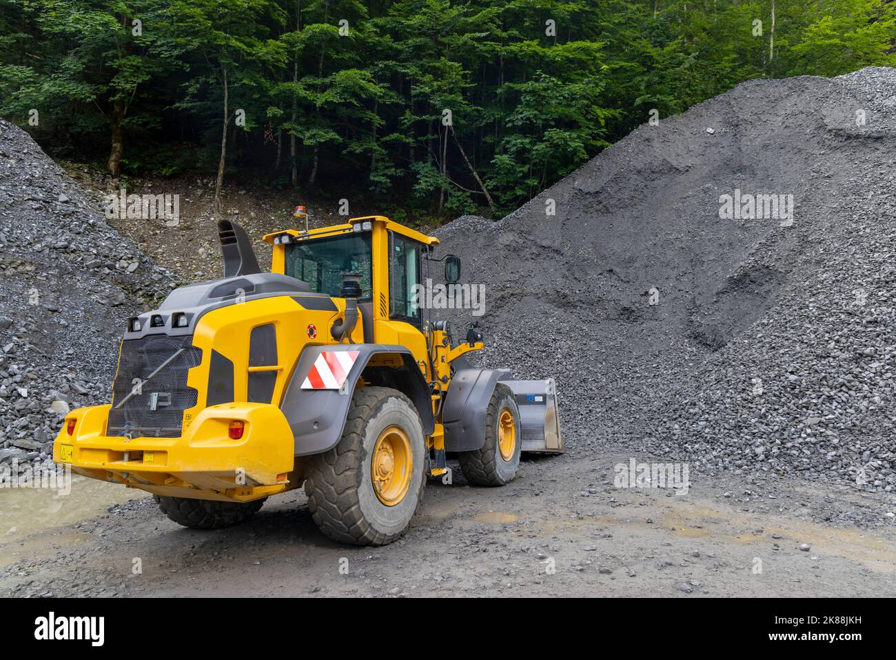 yellow digger with grey gravel for construction of the road Stock Photo ...