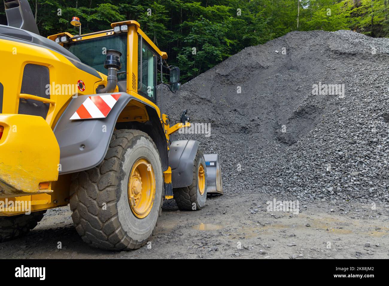 yellow digger with grey gravel for construction of the road Stock Photo ...
