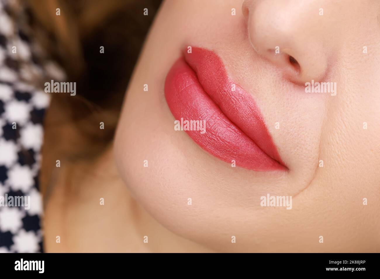 young model With a slight smile, on which permanent lip makeup is done ...