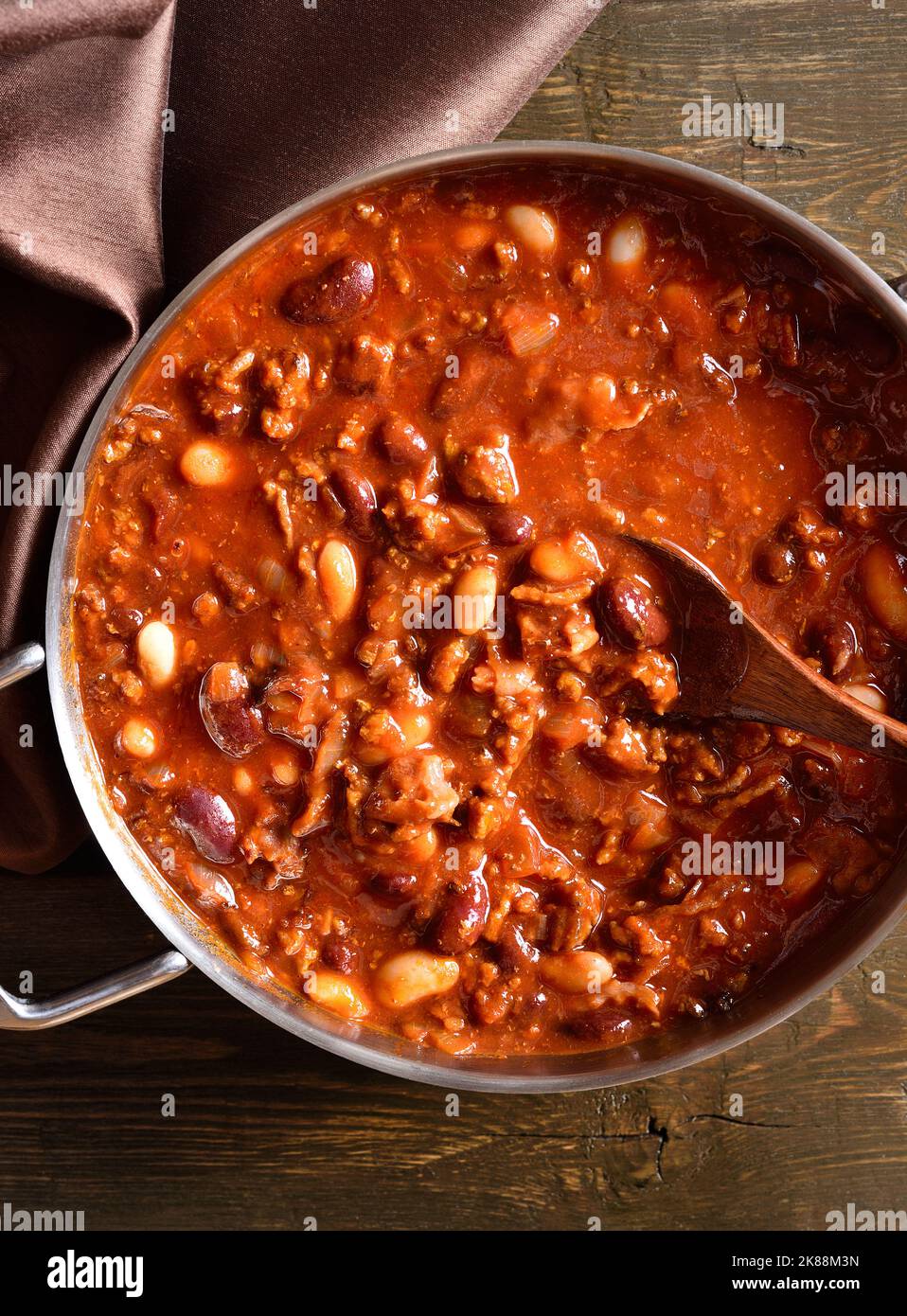 Cowboy beans with ground beef, jalapeno pepper and bacon in cooking pan ...