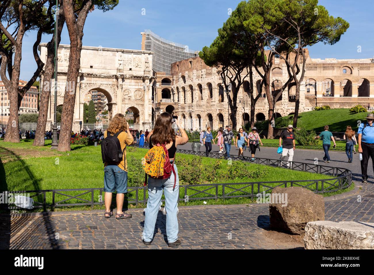 Tourist are seen on the street on a sunny day by the Colosseum the Arch ...