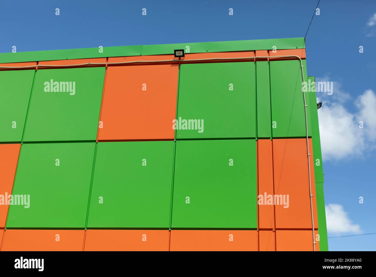 Corner of building. Modern architecture. Green and orange color in ...