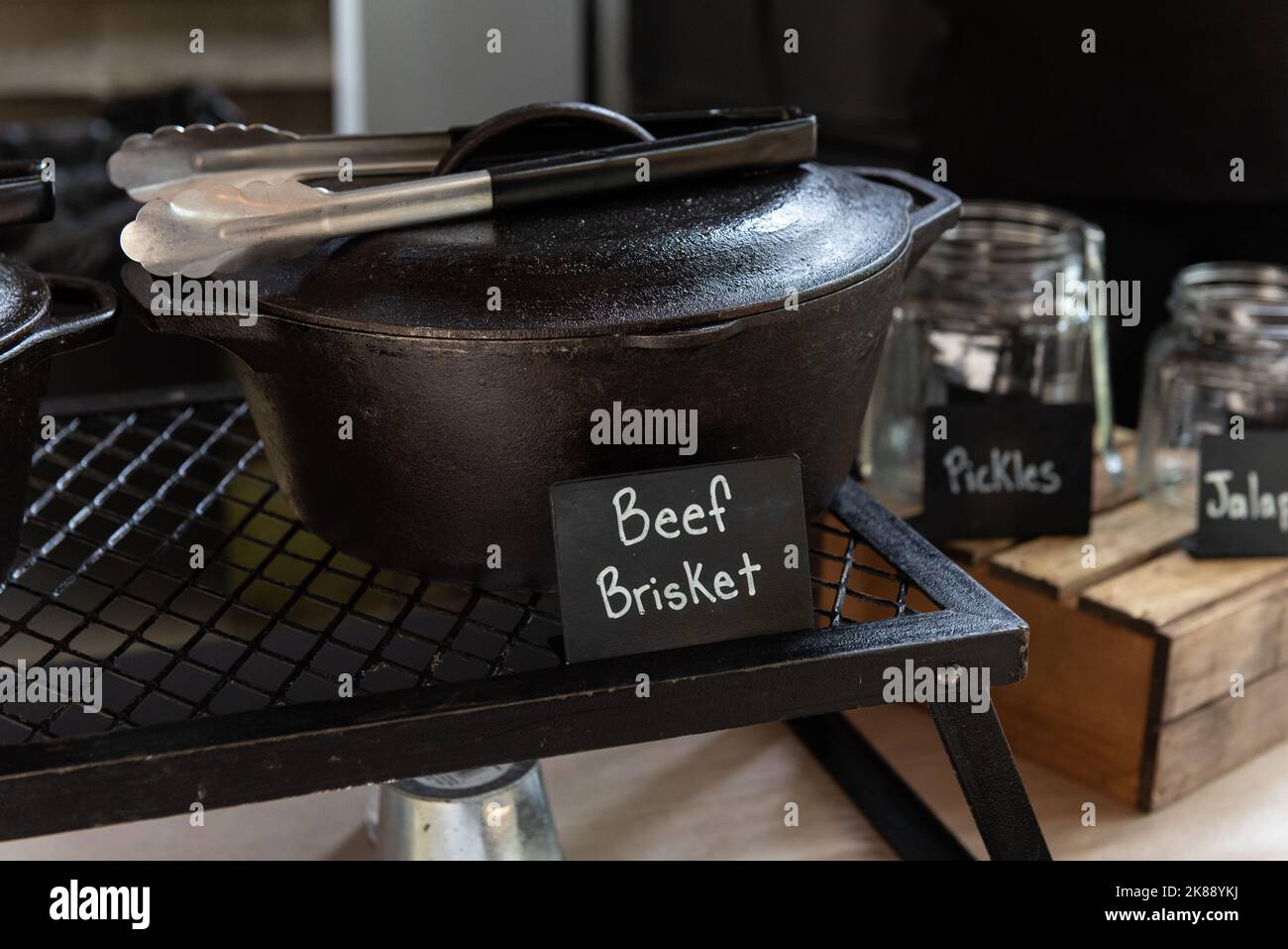 Buffet line has a cast iron pot of beef brisket for the guests to serve ...