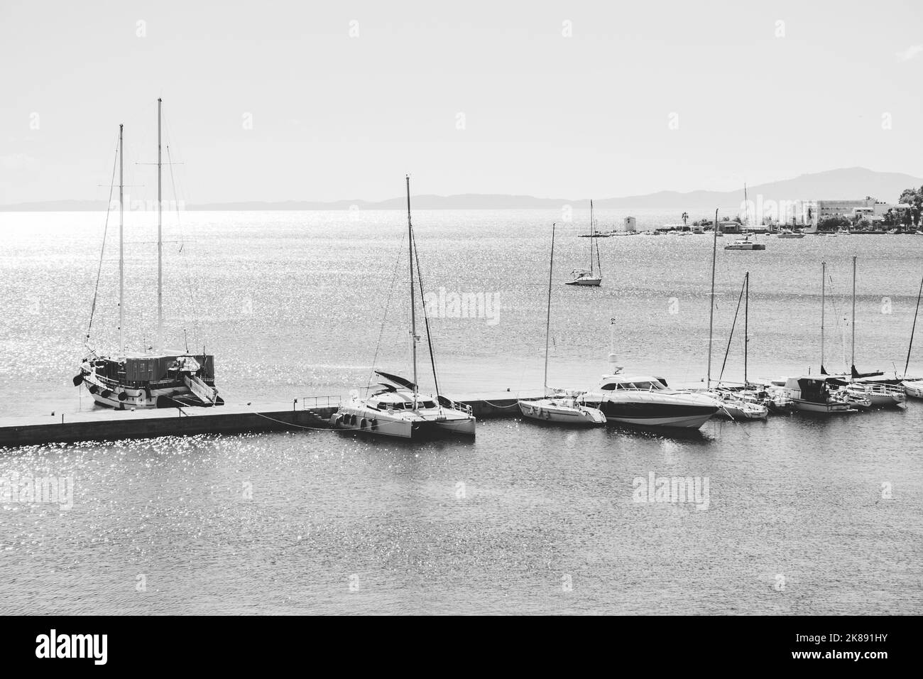 Boat and yacht pier with wooden boardwalk in blue water in Greece Stock ...
