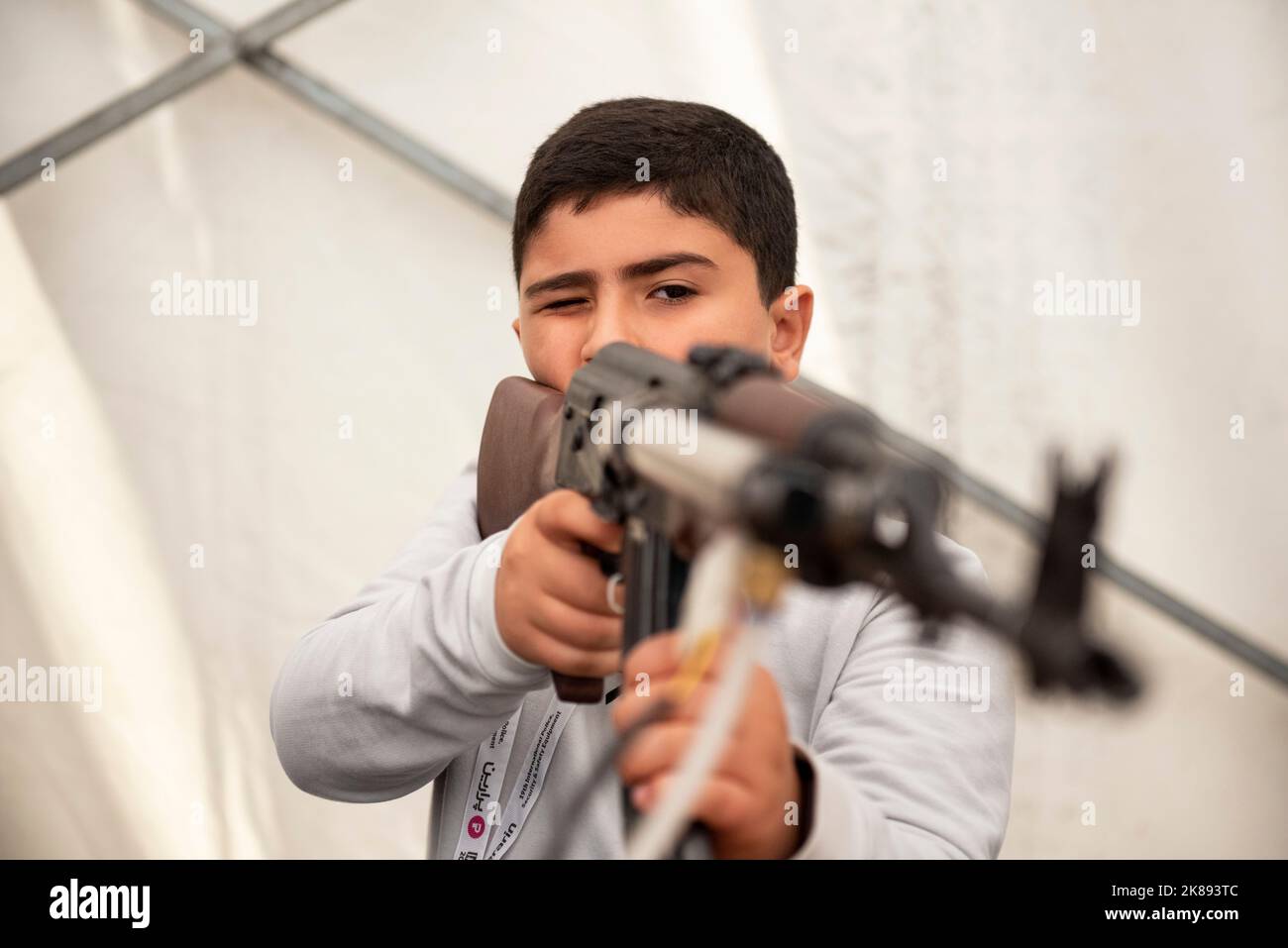 A young boy practice shooting with shooting simulators made in Iran at ...