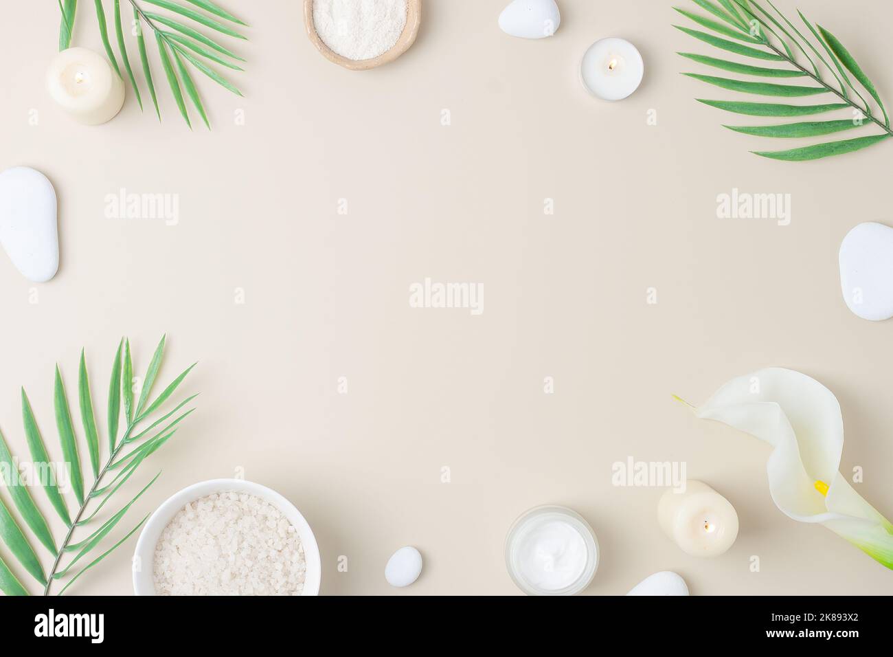 Spa background with skin care products, stones, candles and palm leaves ...