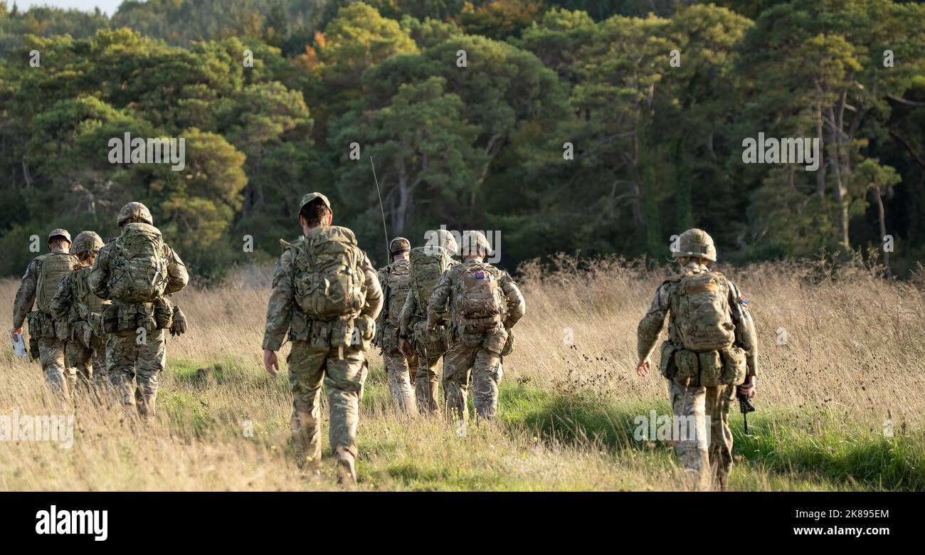 8 British army soldiers tabbing with 25Kg bergens across open ...