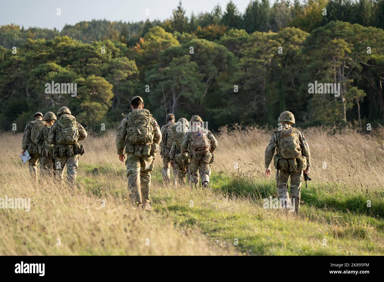 8 British army soldiers tabbing with 25Kg bergens across open ...