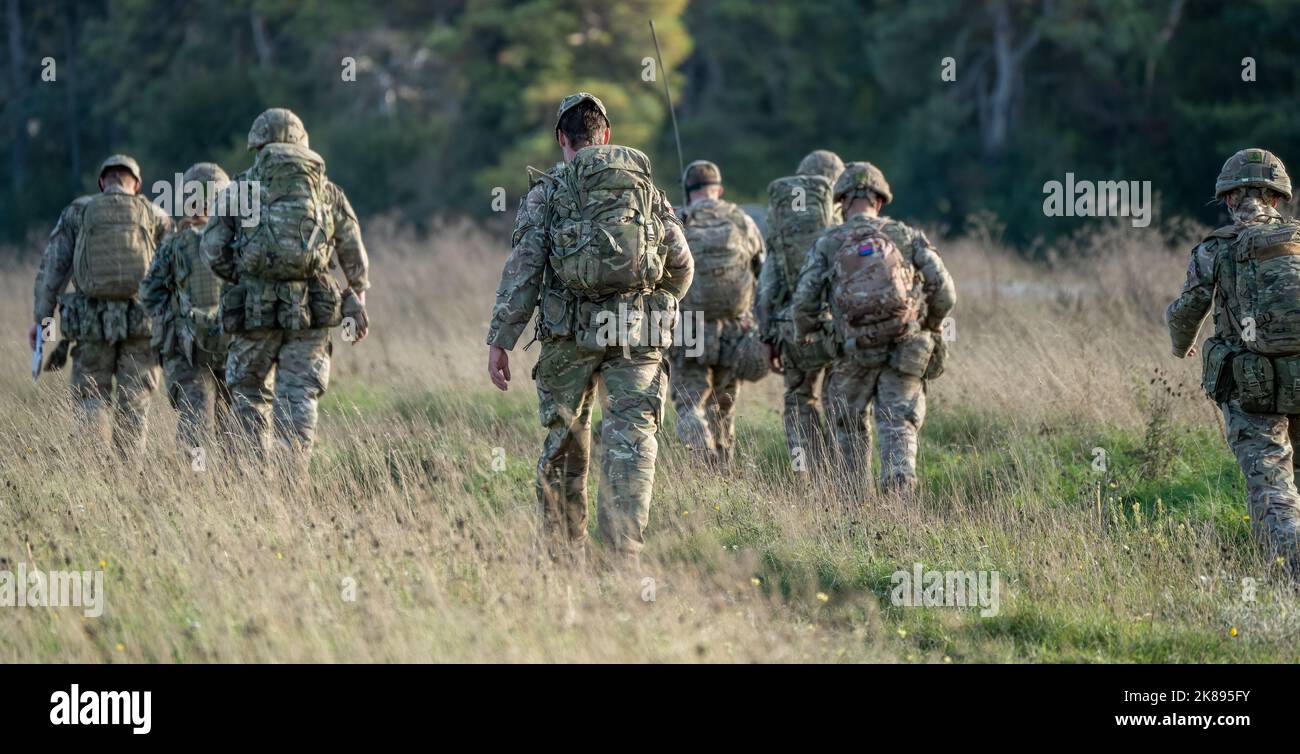 8 British army soldiers tabbing with 25Kg bergens across open ...