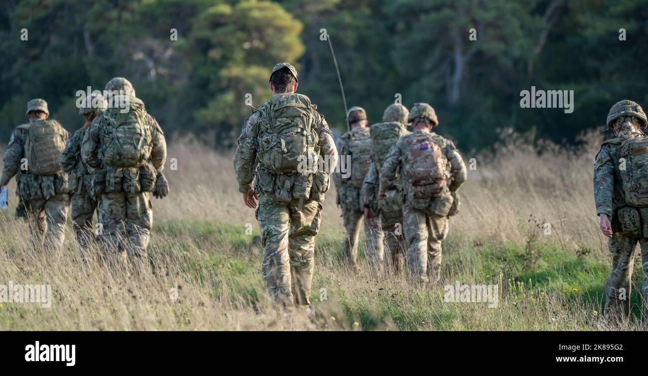 8 British army soldiers tabbing with 25Kg bergens across open ...